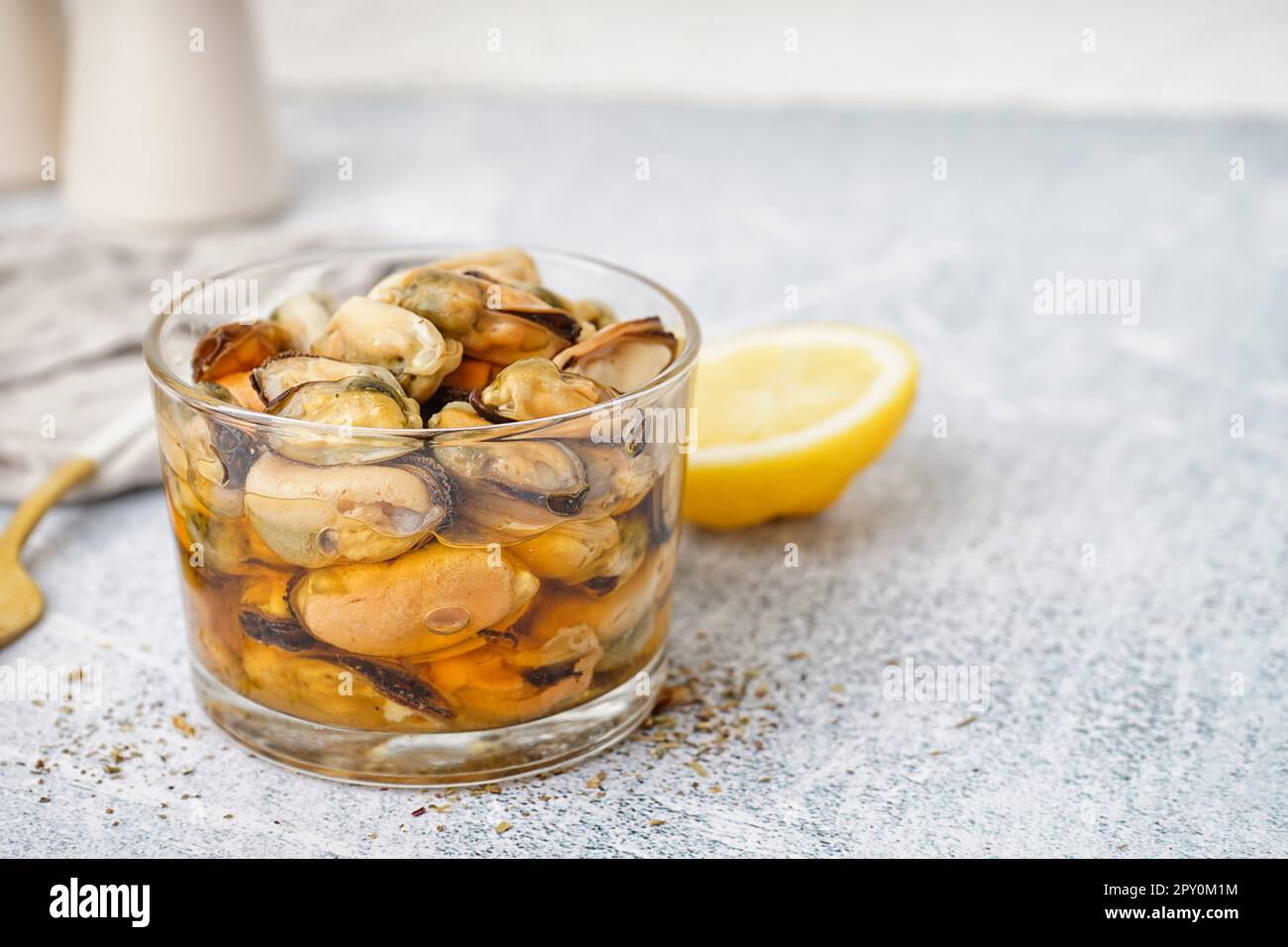 Glass bowl with pickled mussels on grey background Stock Photo - Alamy