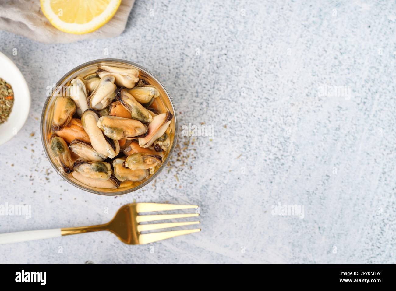 Glass bowl with pickled mussels on grey background Stock Photo - Alamy
