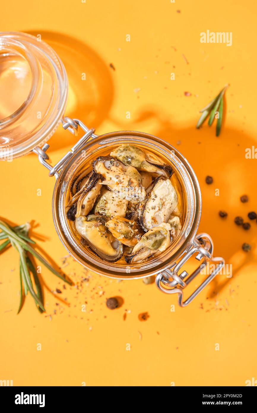 Jar with pickled mussels on orange background Stock Photo - Alamy