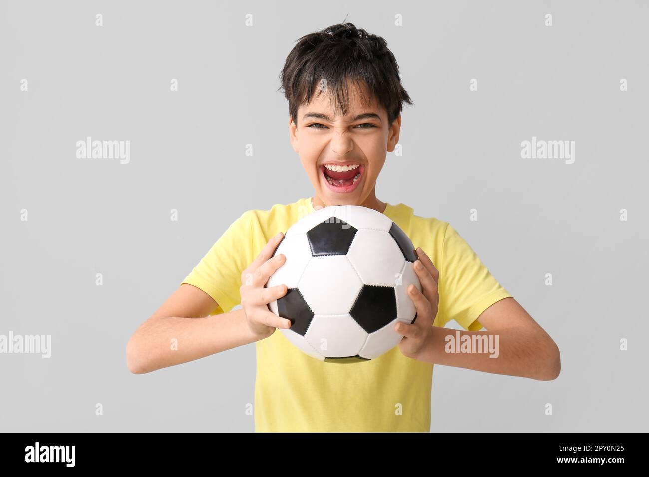 Aggressive little boy with soccer ball on grey background Stock Photo ...
