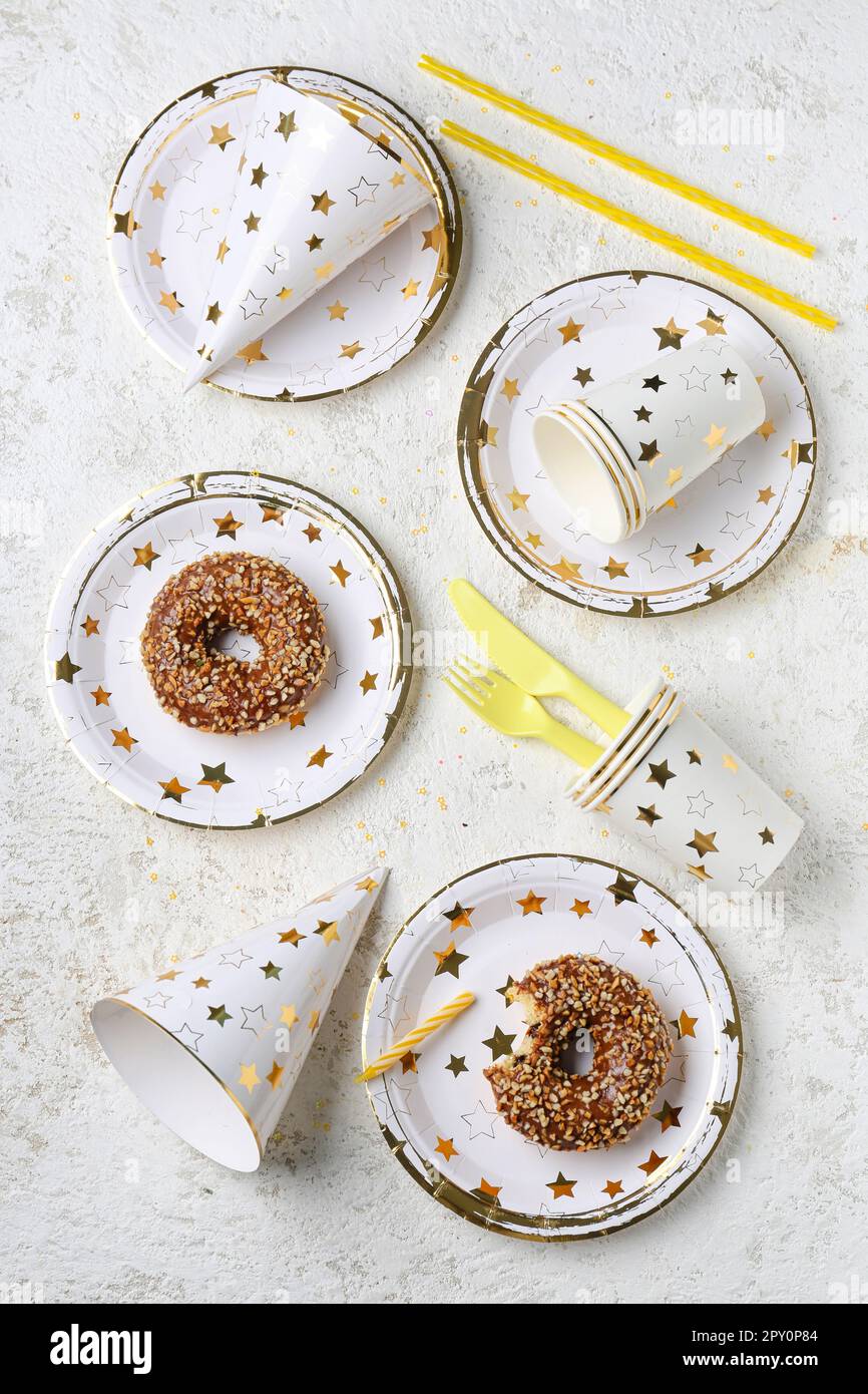 Paper disposable tableware with donuts, party hats and candles on ...