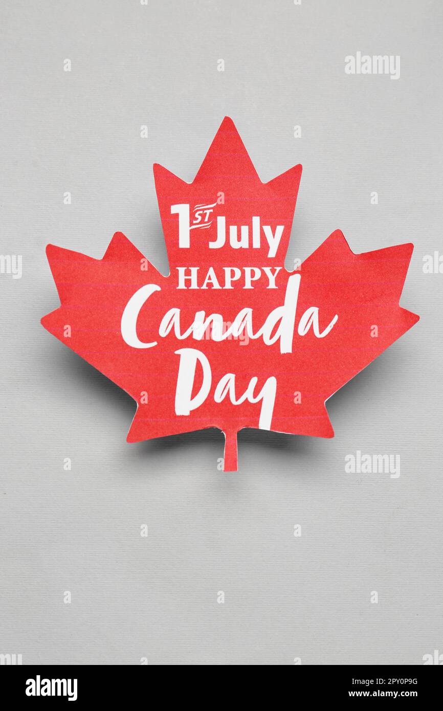 Paper maple leaf with text 1ST JULY HAPPY CANADA DAY on grey background ...