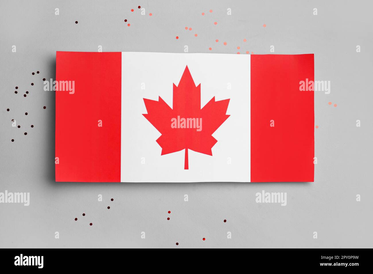 Paper flag of Canada with confetti on grey background Stock Photo - Alamy