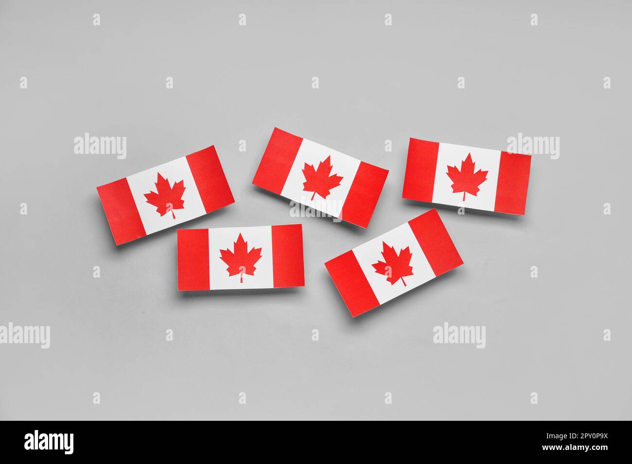Paper flags of Canada on grey background Stock Photo - Alamy