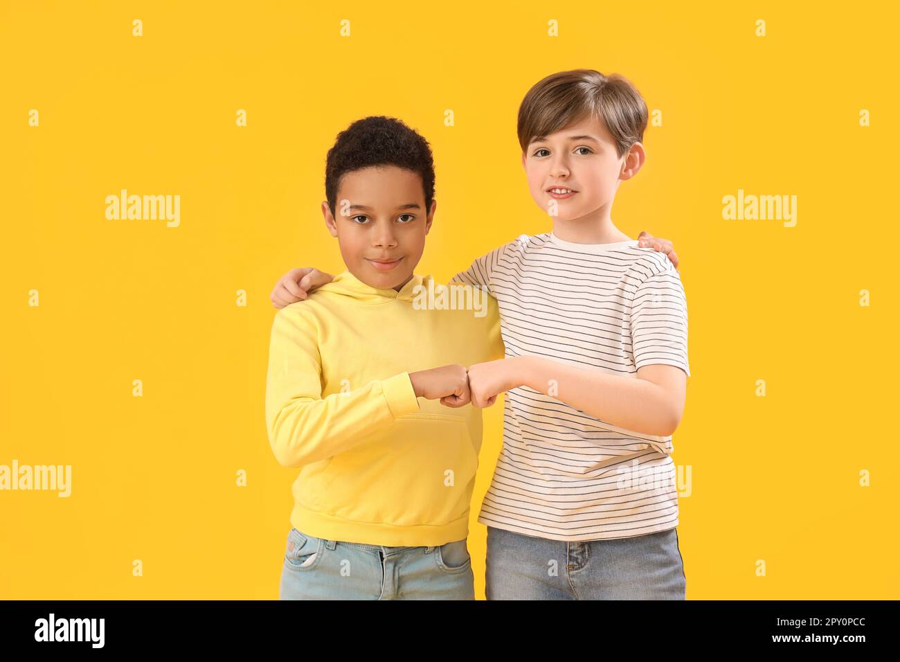 Little boys bumping fists on yellow background. Children's Day ...