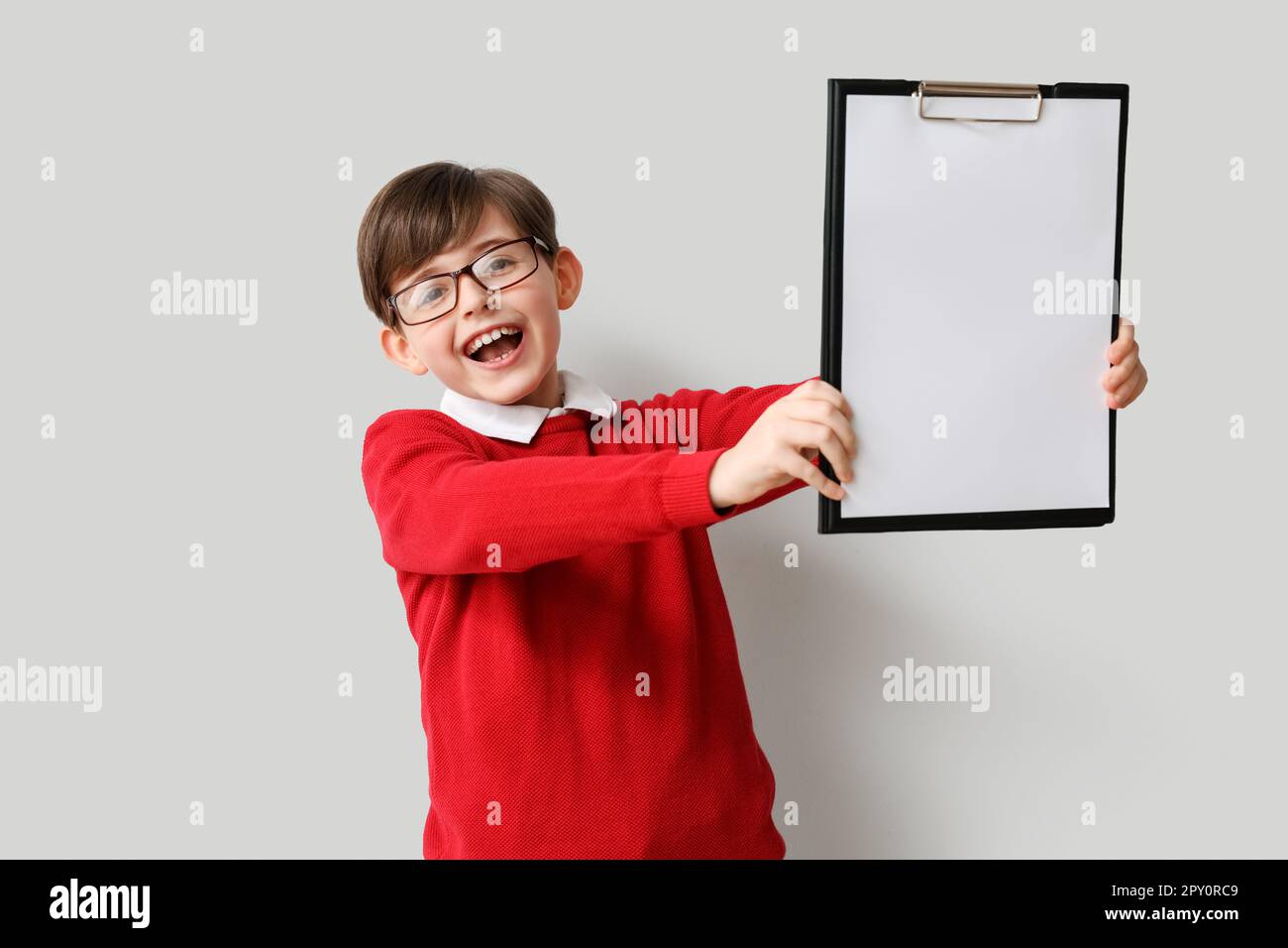 Little boy with clipboard on light background. Children's Day ...