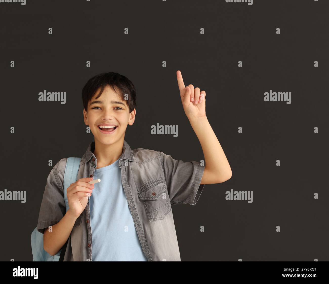 Little boy pointing at something against blackboard. Children's Day ...