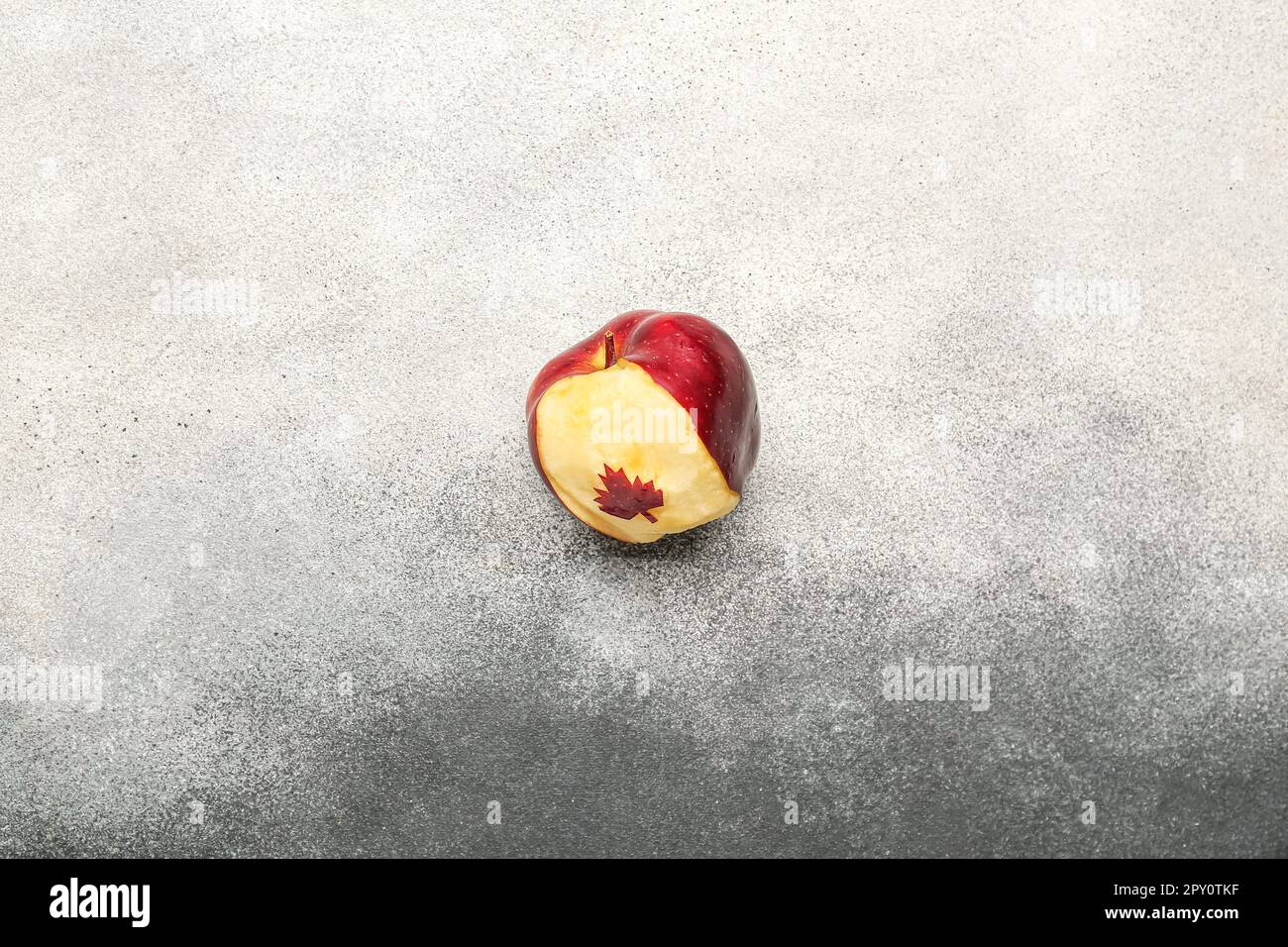 Apple with cut maple leaf on black and white background. Canadian flag ...