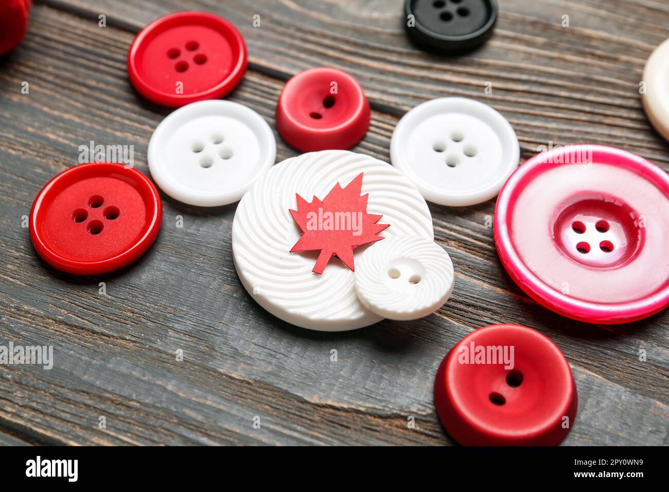 Buttons with paper maple leaf on dark wooden background, closeup ...