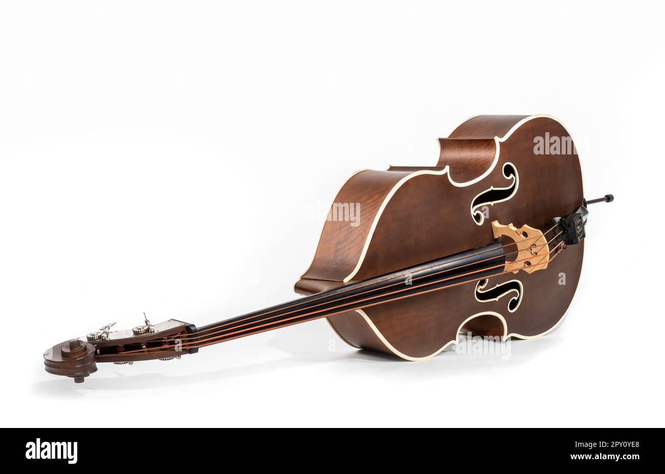 old brown double bass lies on the floor in front of a white background ...