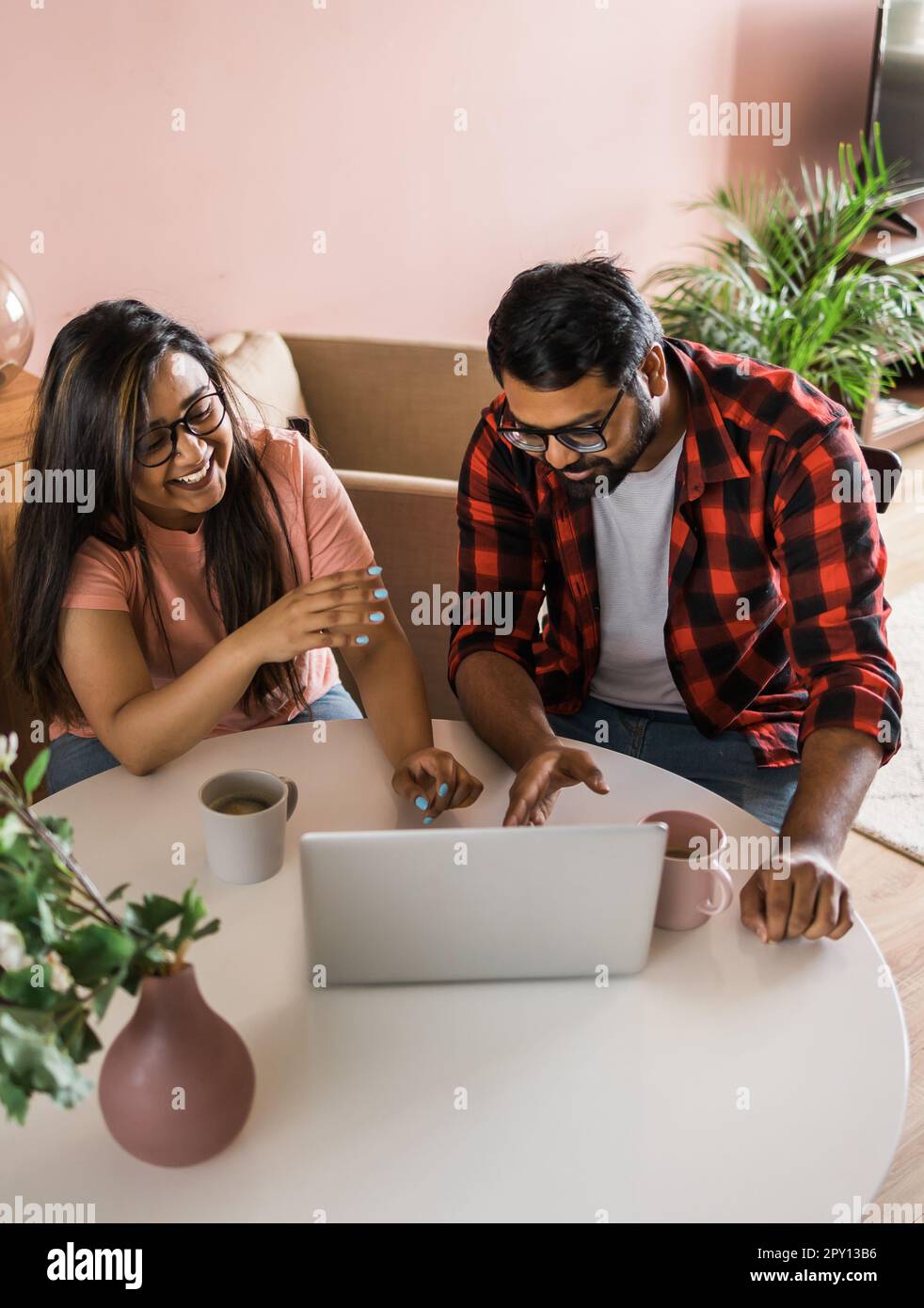 Happy indian family couple cuddle at desk make video call to friends ...