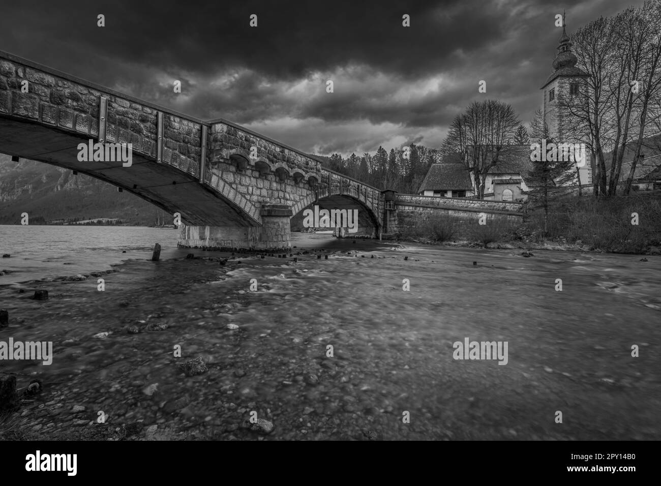 Dark cloudy sunny evening with no colors near Bohinj lake with old ...