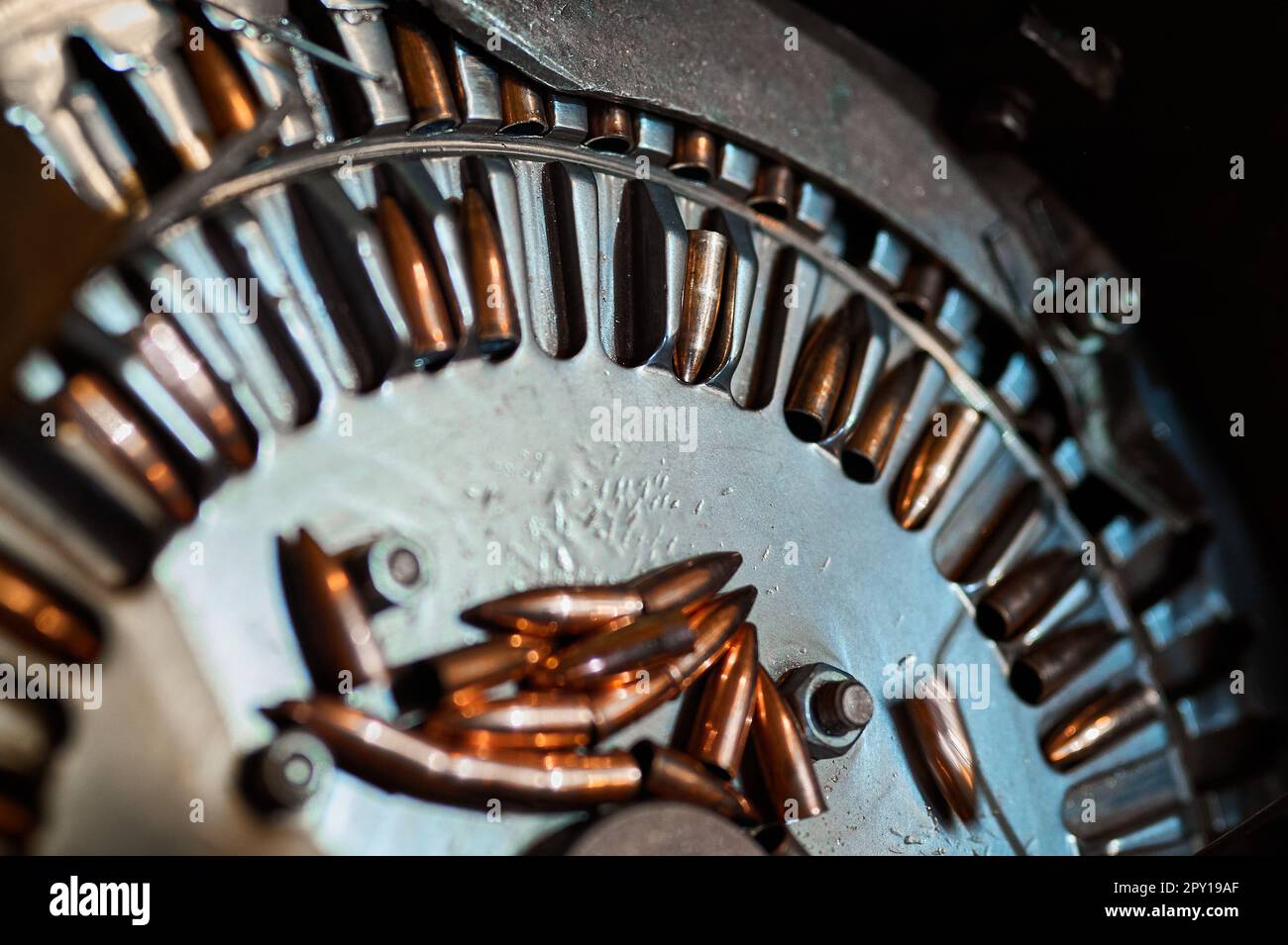Pile of orange bullets and turning wheel at production line Stock Photo ...