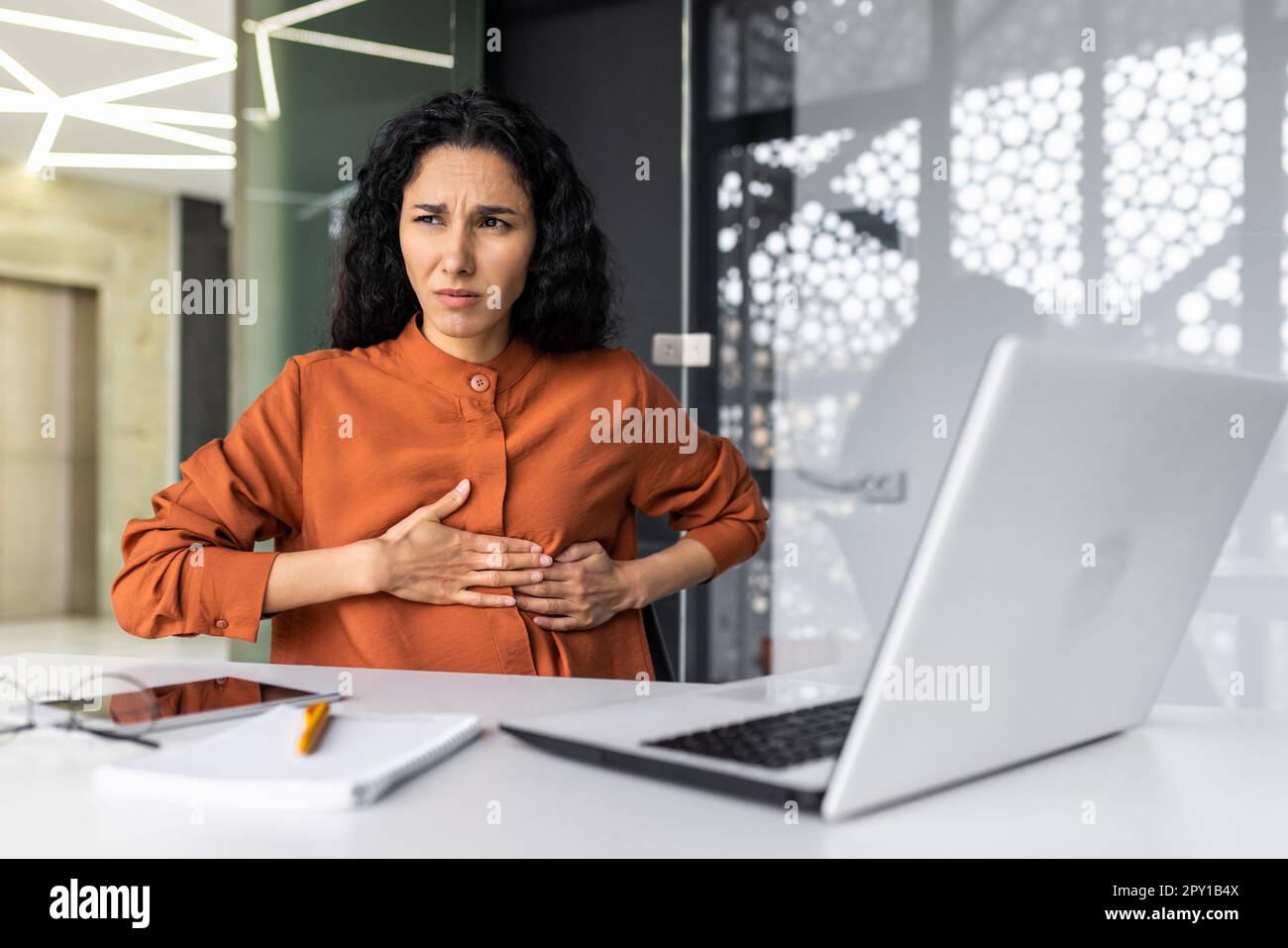 Anxious and scared business woman working inside office, Hispanic woman ...