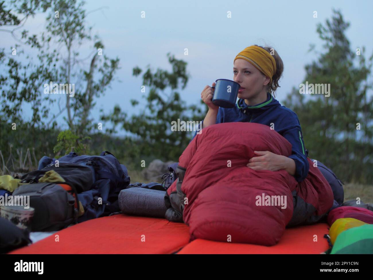 Female hiker drinking while caming Stock Photo - Alamy