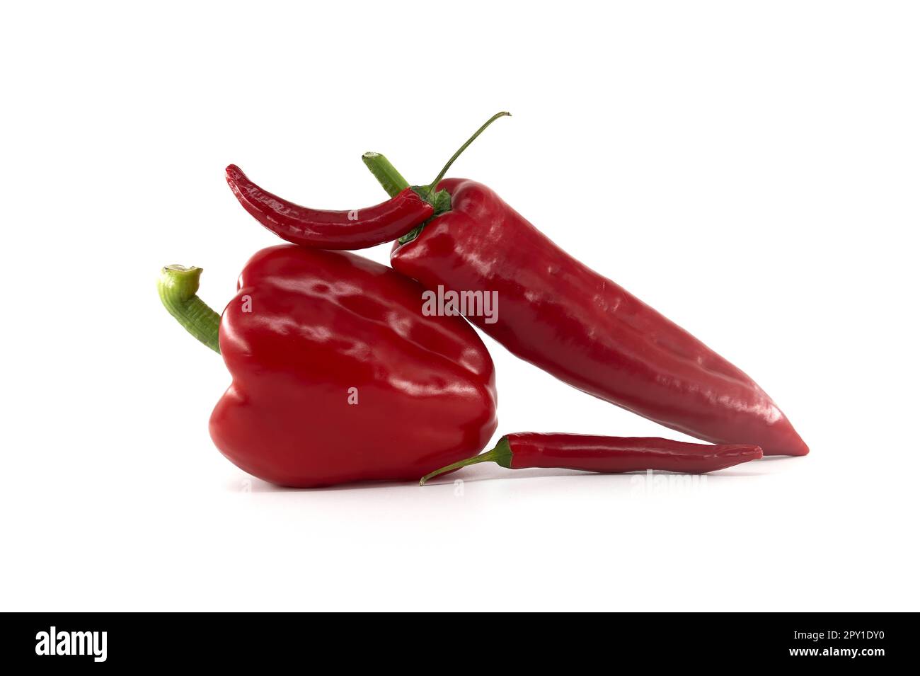 A stack of fresh chili peppers and red bell peppers isolated on white ...