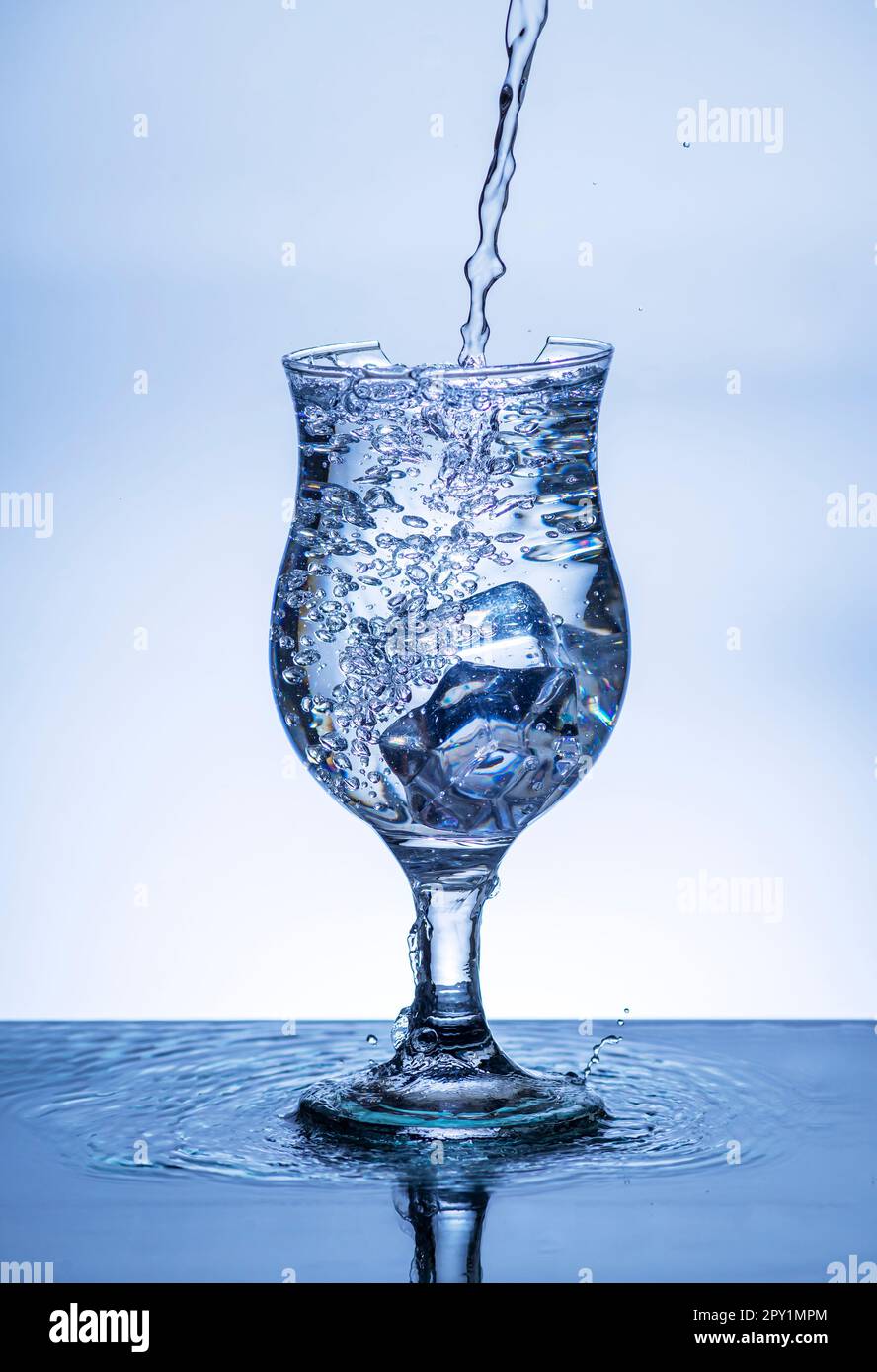 The image of pouring drinking water, into a broken glass, that makes ...