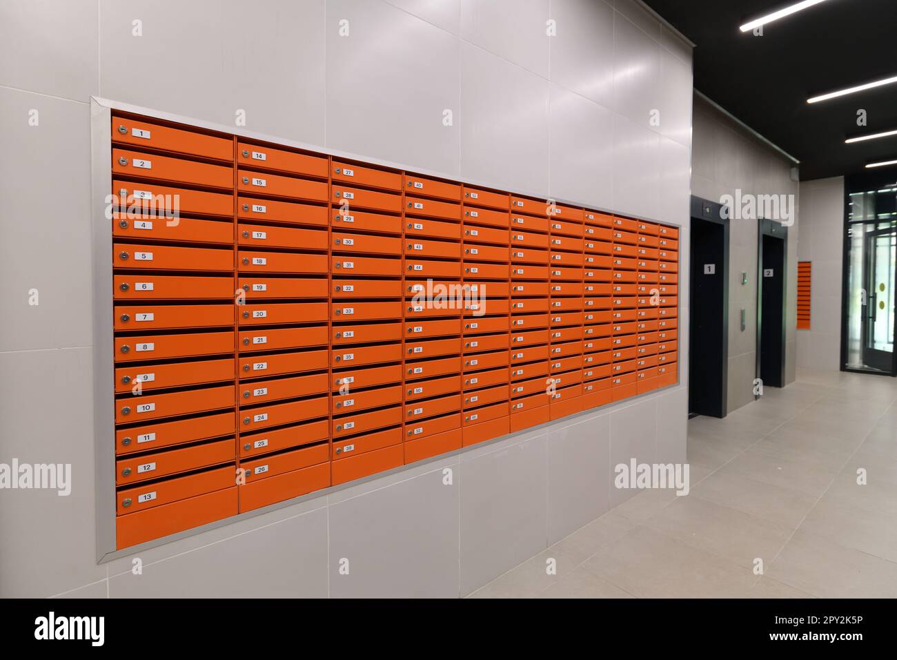 Orange mailboxes in the interior of the entrance group of a residential ...
