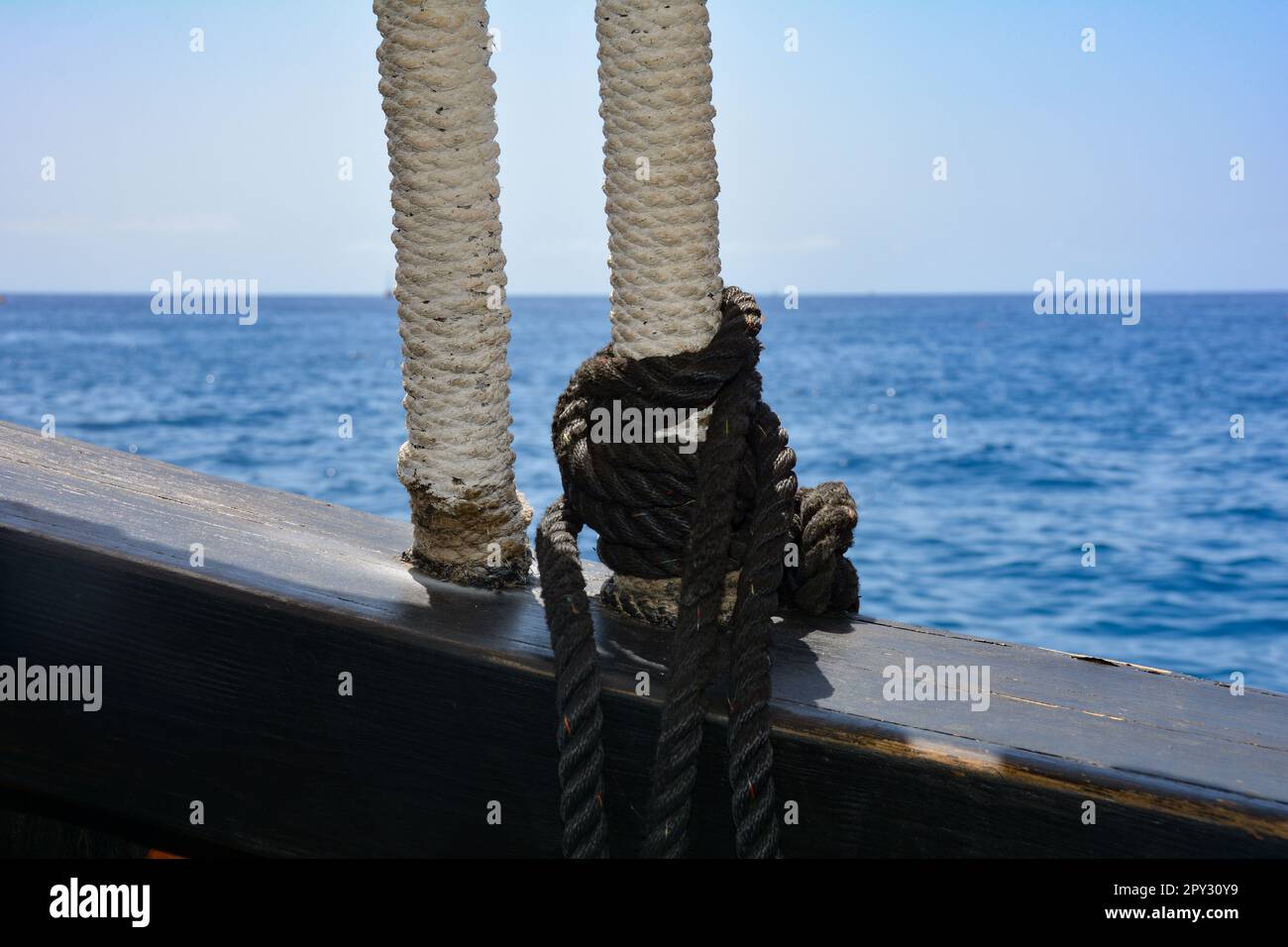 Part of an old sailing ship with ropes and facing the open sea Stock ...