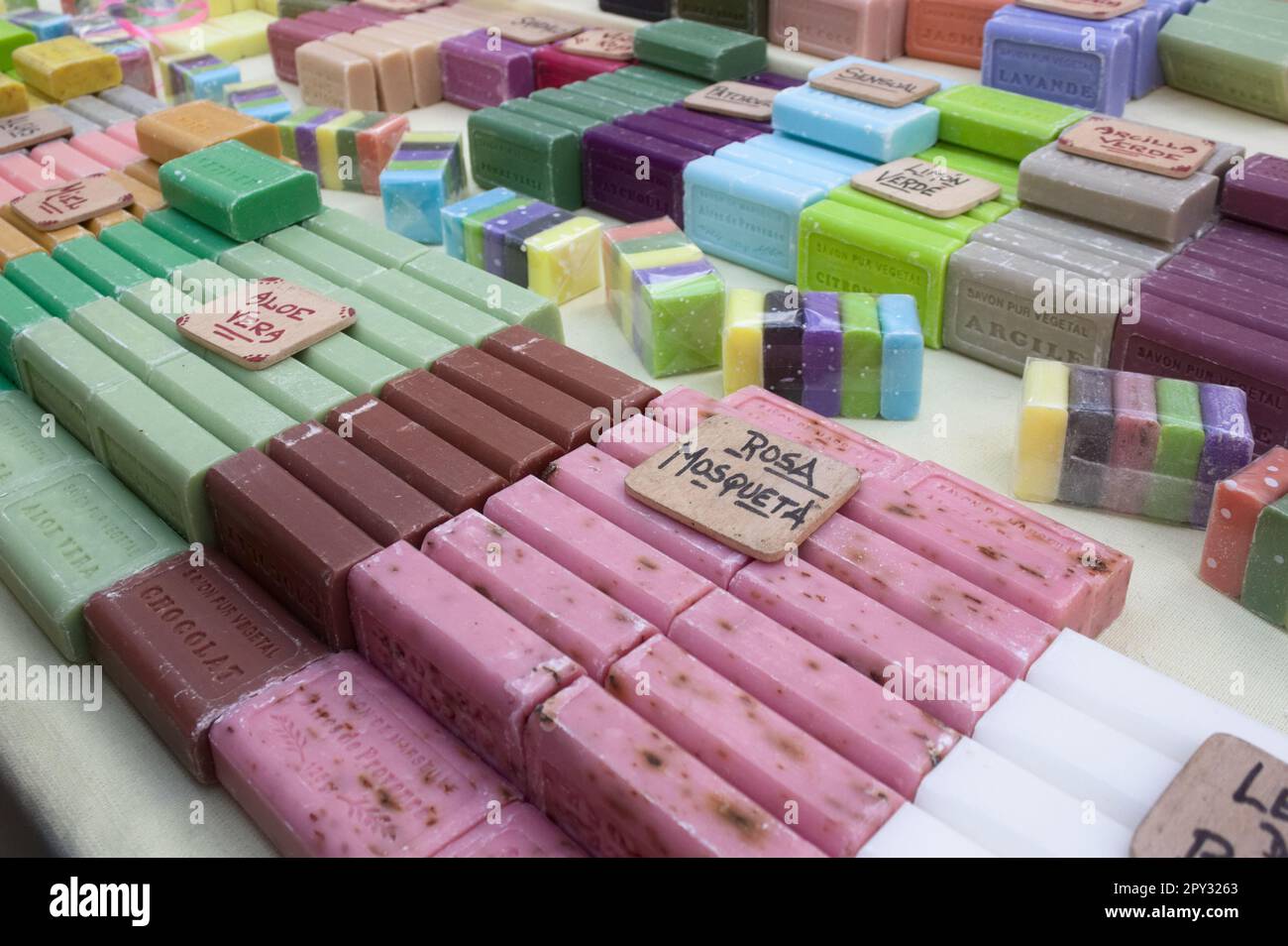 Close-up of a market stall where multiple varieties of natural soaps ...