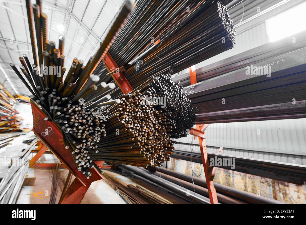 Thin metal rods stack on large rack in cold plant warehouse Stock Photo ...