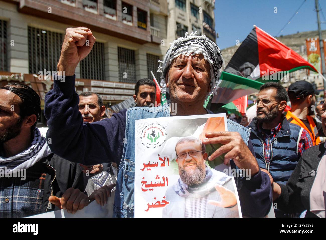 A protester holds a portrait of the late Palestinian prisoner Khader ...