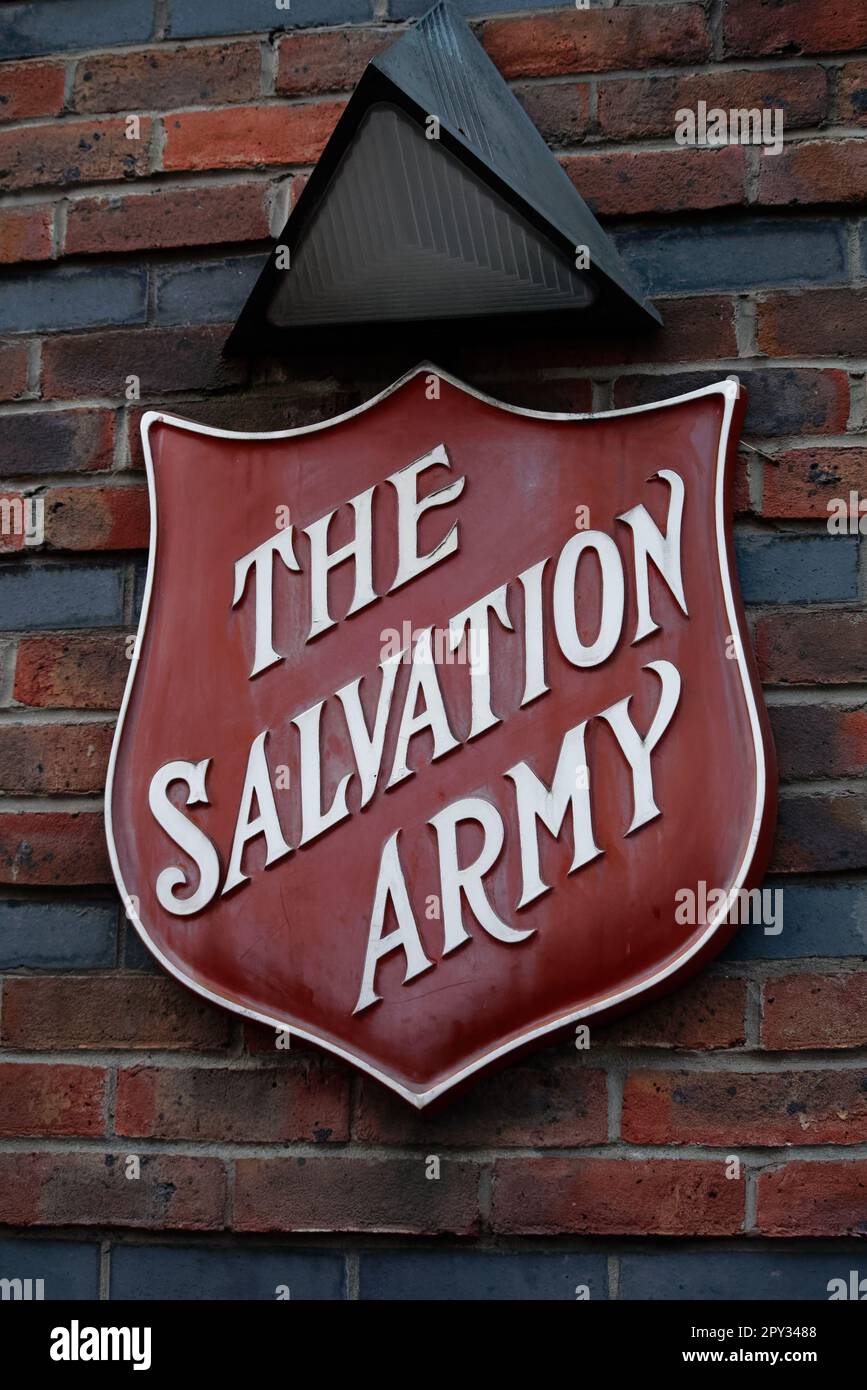 A vertical shot of the Salvation Army emblem mounted on a brick wall in ...