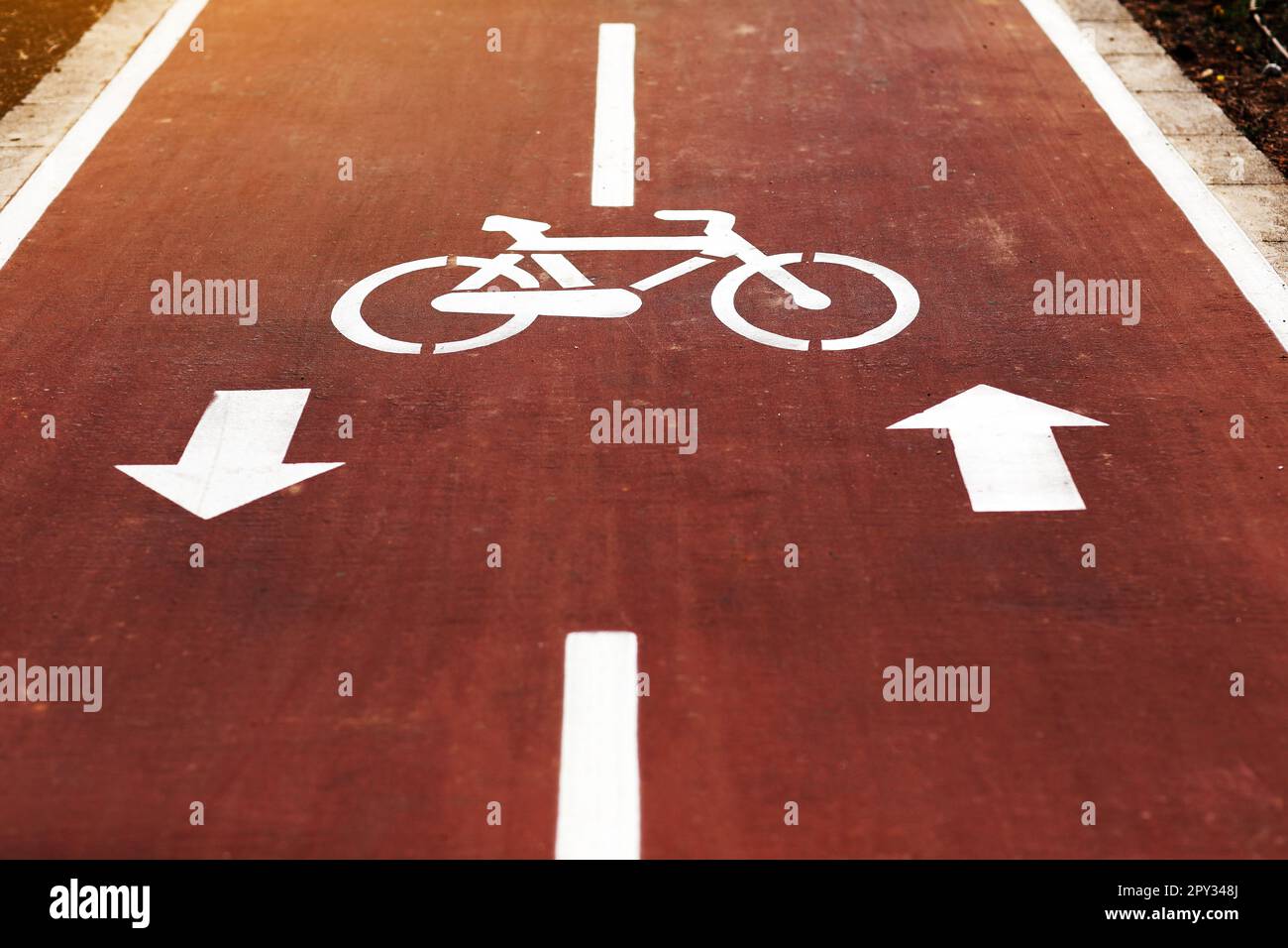 New marking bike path. White bicycle symbol and two oposite arrows on ...