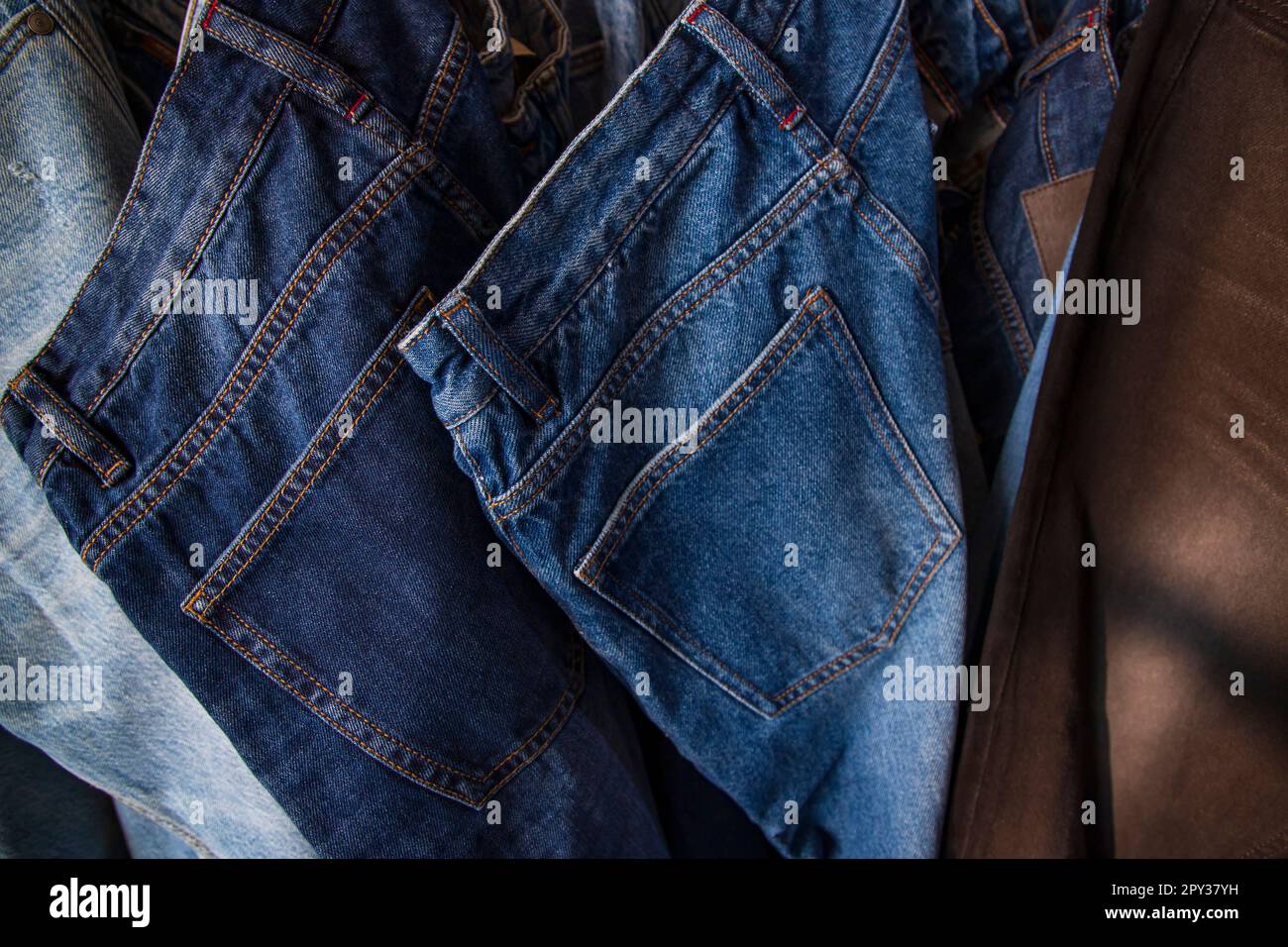 Jeans hanging on a rack in a store, close-up Stock Photo - Alamy