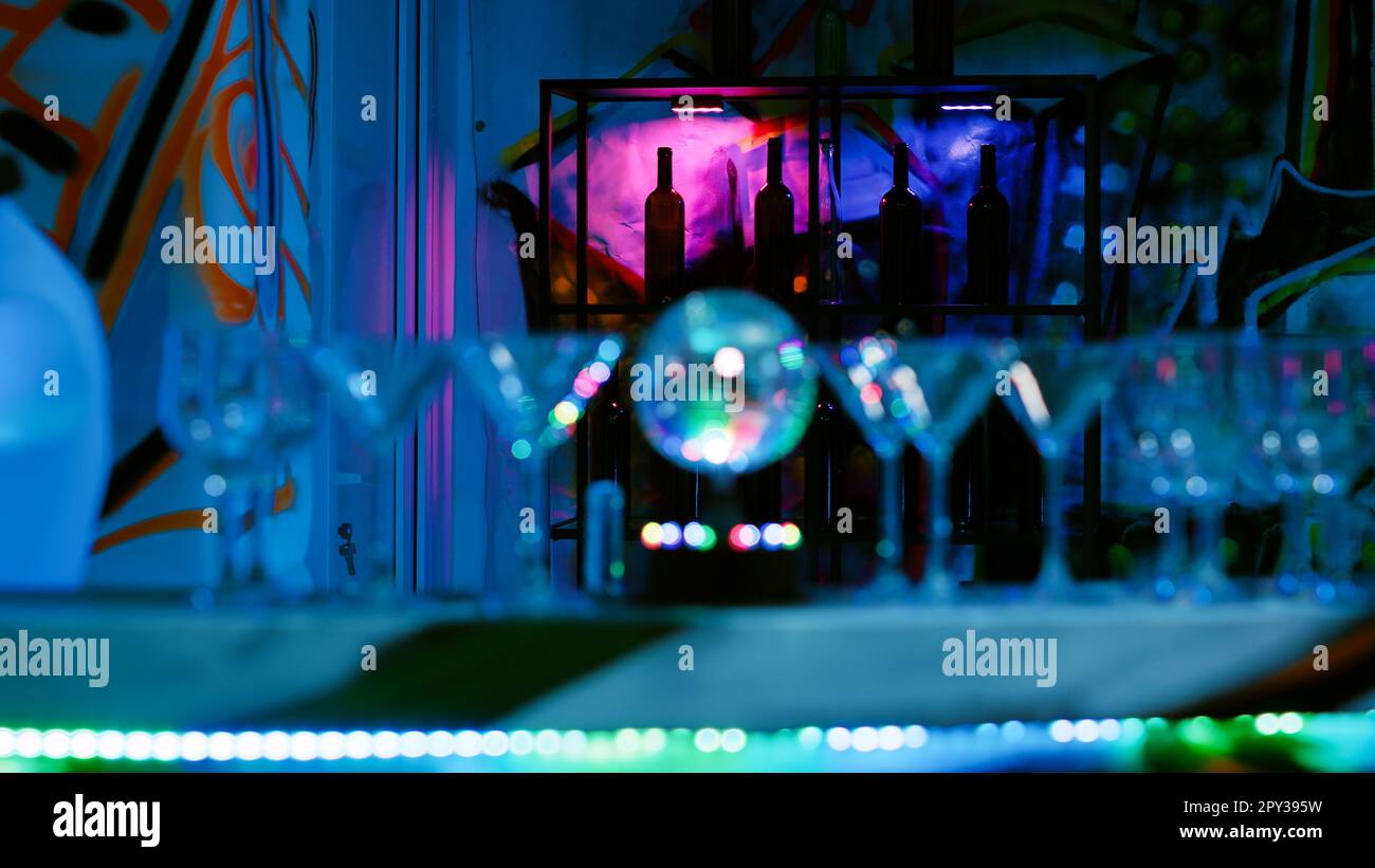 Empty bar with alcohol drinks and disco ball, glasses in the nightclub ...