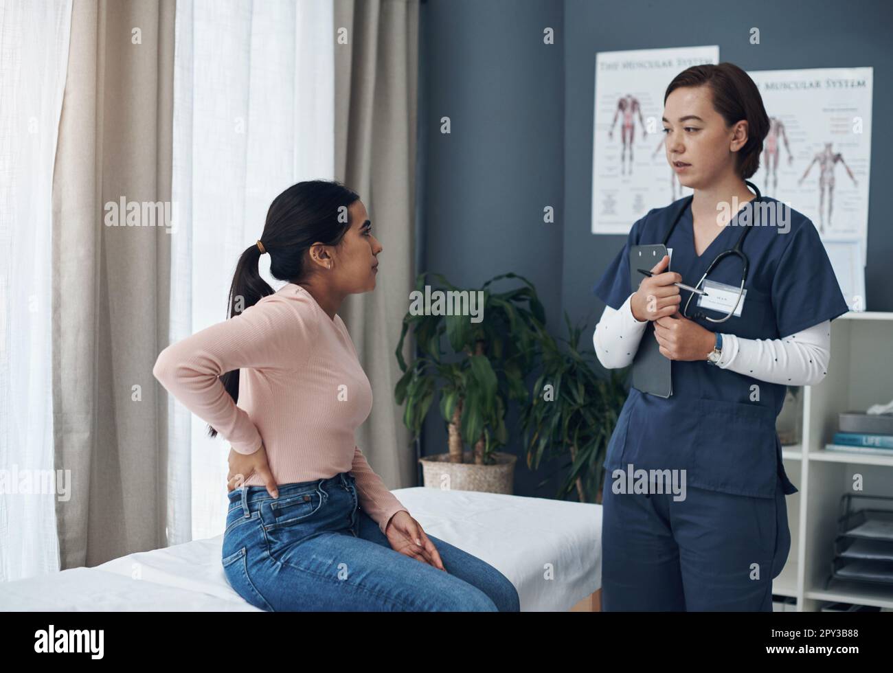 My back hurts the most. a young female doctor talking to a patient in ...