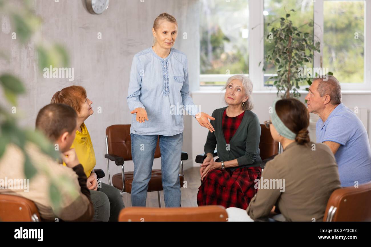 Elderly people communicating in language club with female tutor Stock ...