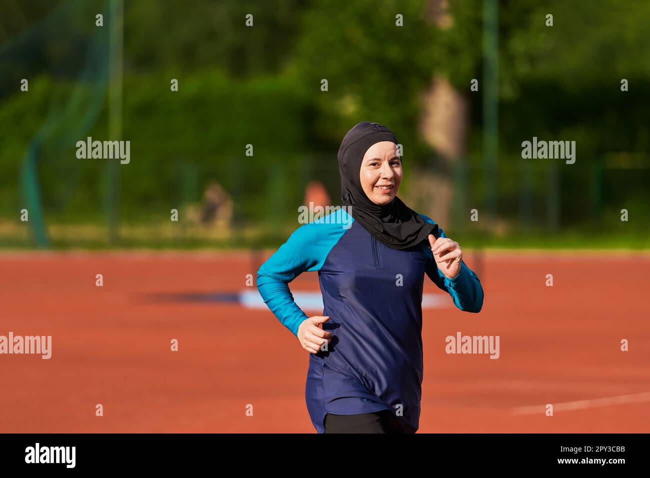 A muslim woman in a burqa sports muslim clothes running on a marathon ...