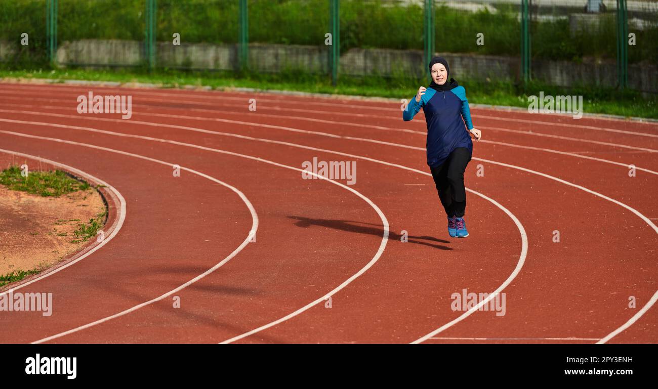 A muslim woman in a burqa sports muslim clothes running on a marathon ...