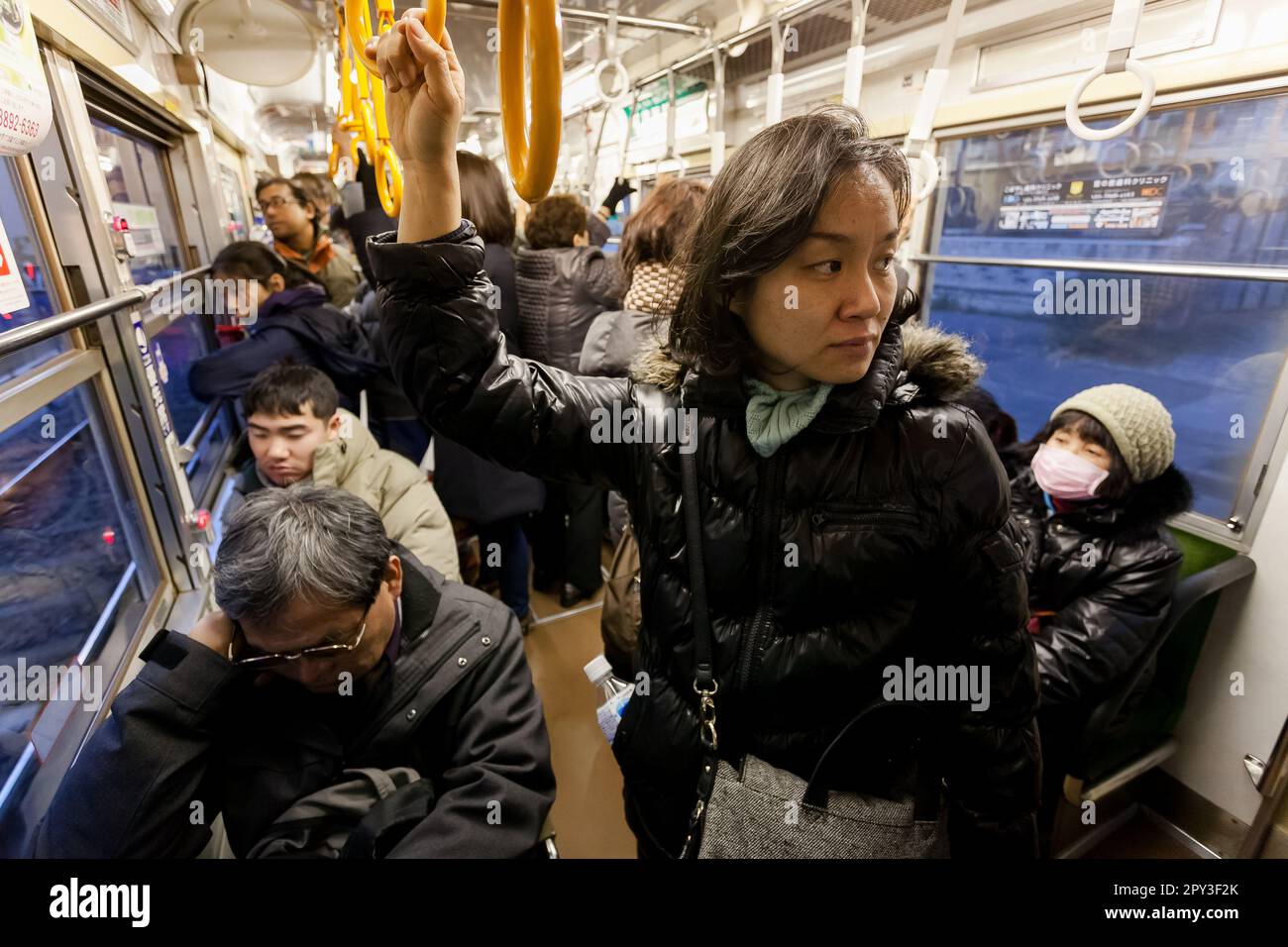 Passengers ride a street car or tram on the Toden Arakawa Line (known ...
