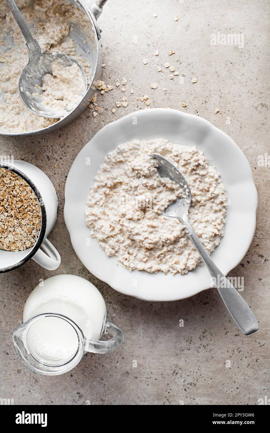 Oatmeal plate. Cooked oatmeal served with fresh milk. Healthy food ...