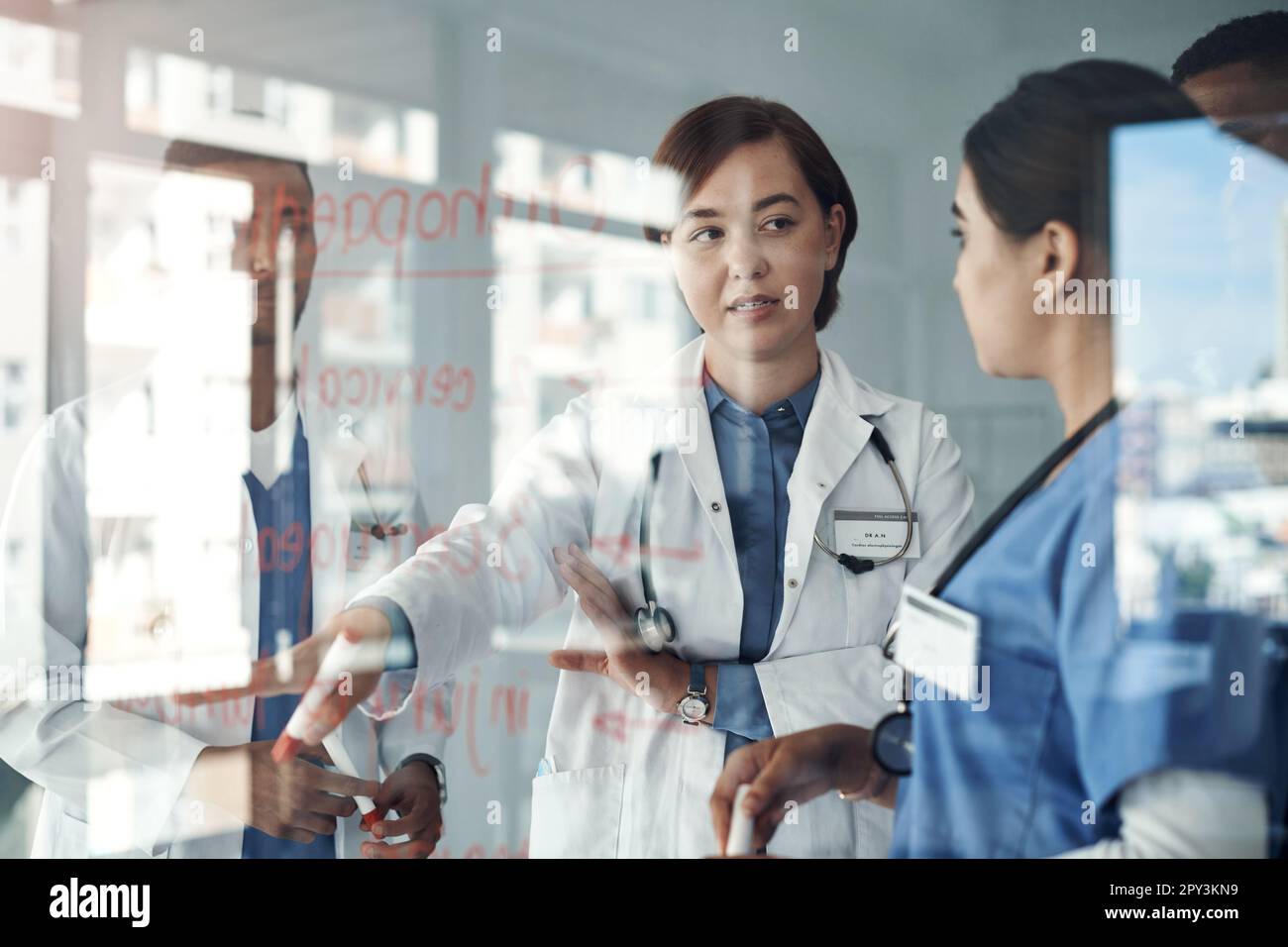 Great minds think alike. Shot a group of doctors discussing formulas in ...