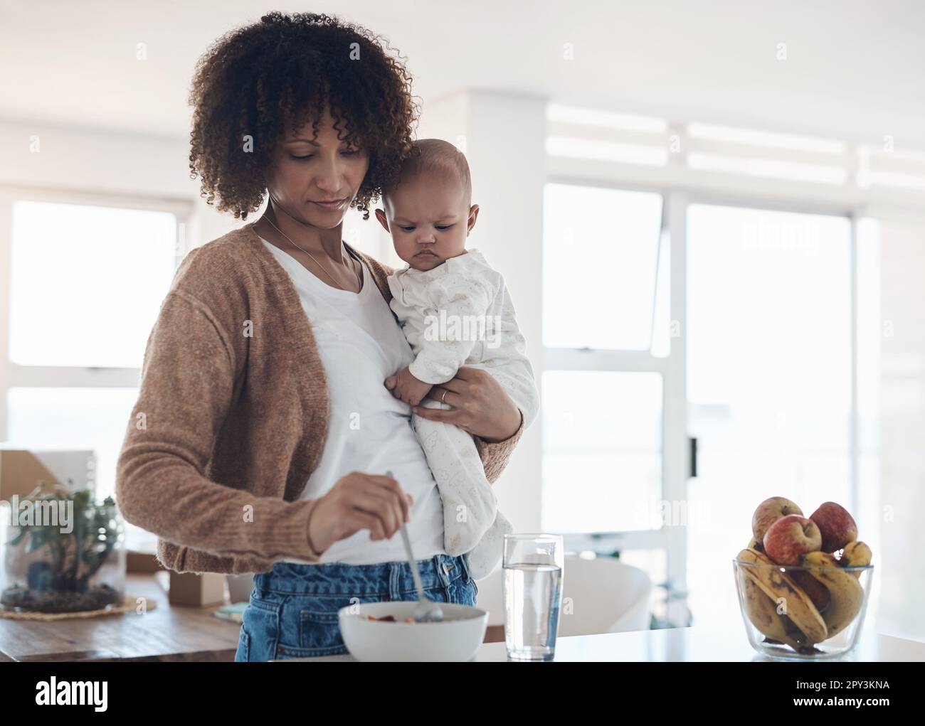 Having something yummy with mummy. a young woman preparing a meal for ...