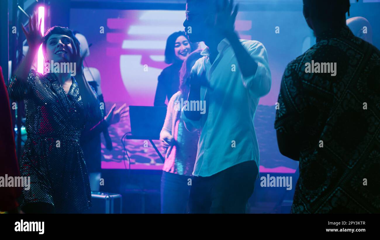 Diverse people dancing together at club, doing funky dance moves on ...