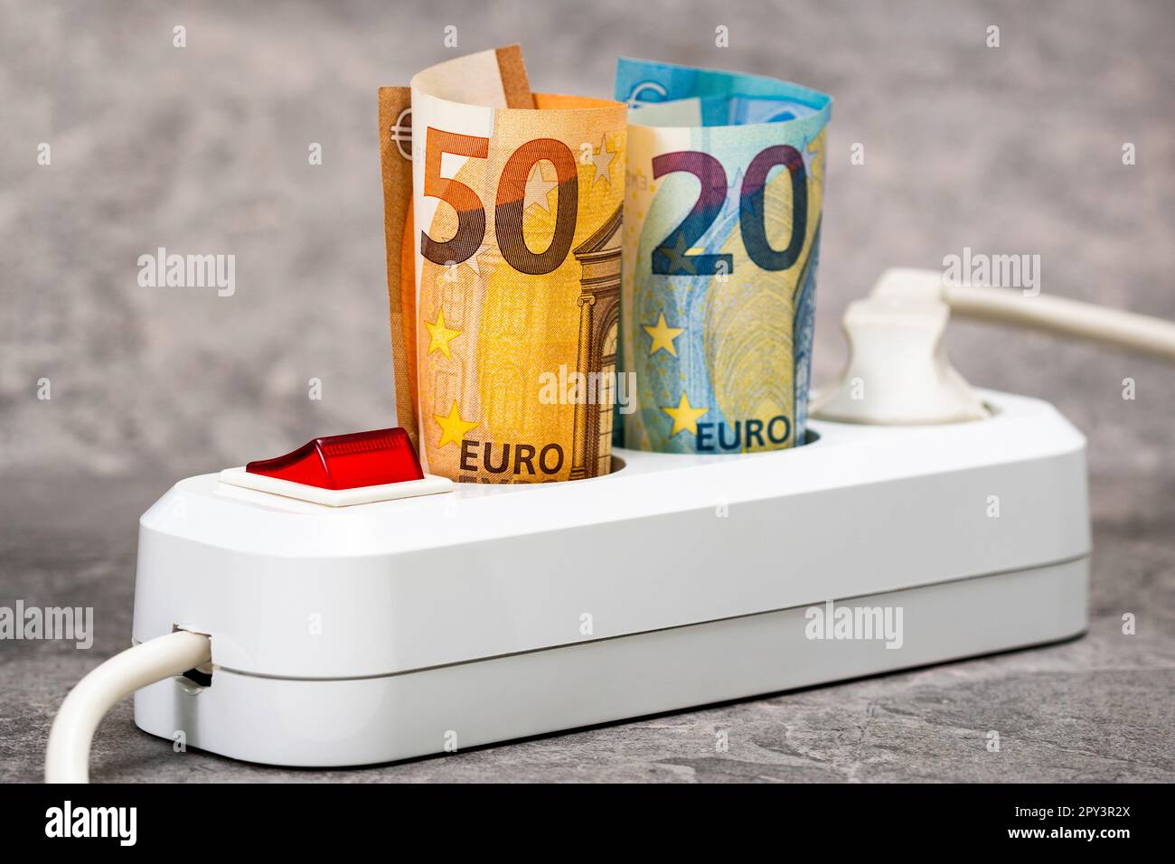 Euro money banknotes plugged into a white power strip.Concept of ...