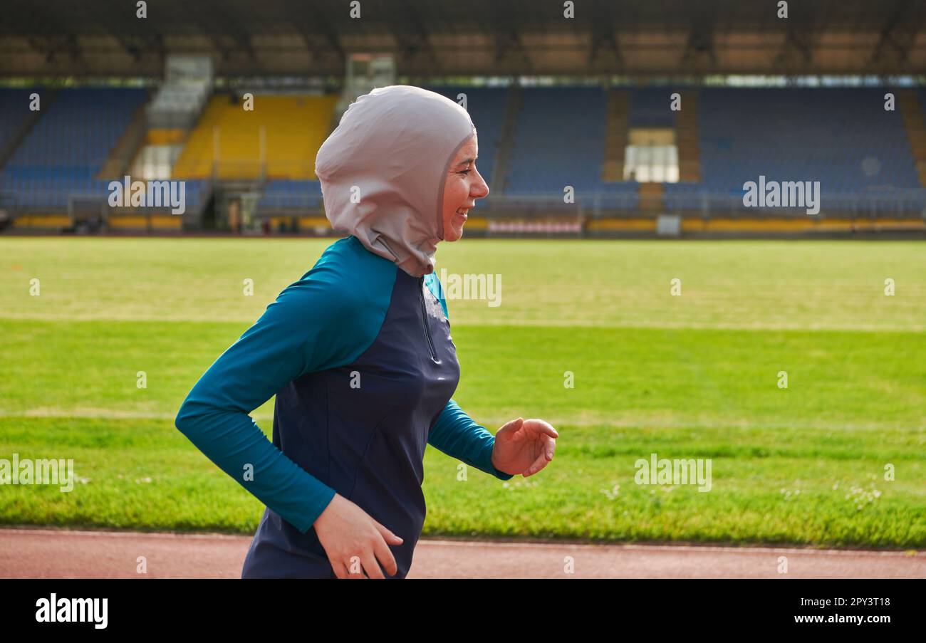 A muslim woman in a burqa sports muslim clothes running on a marathon ...