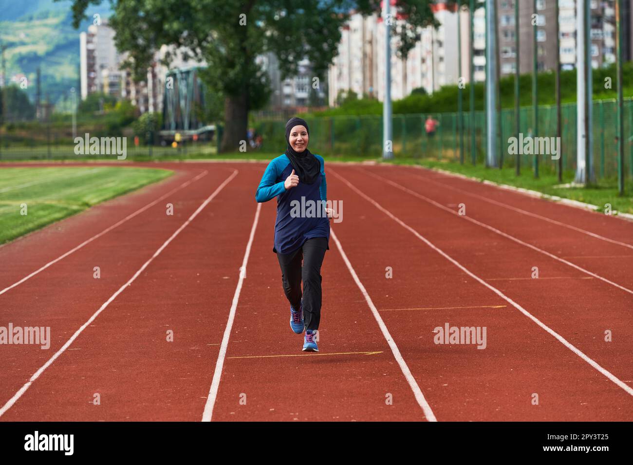 A muslim woman in a burqa sports muslim clothes running on a marathon ...