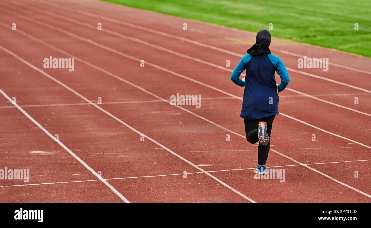 A muslim woman in a burqa sports muslim clothes running on a marathon ...
