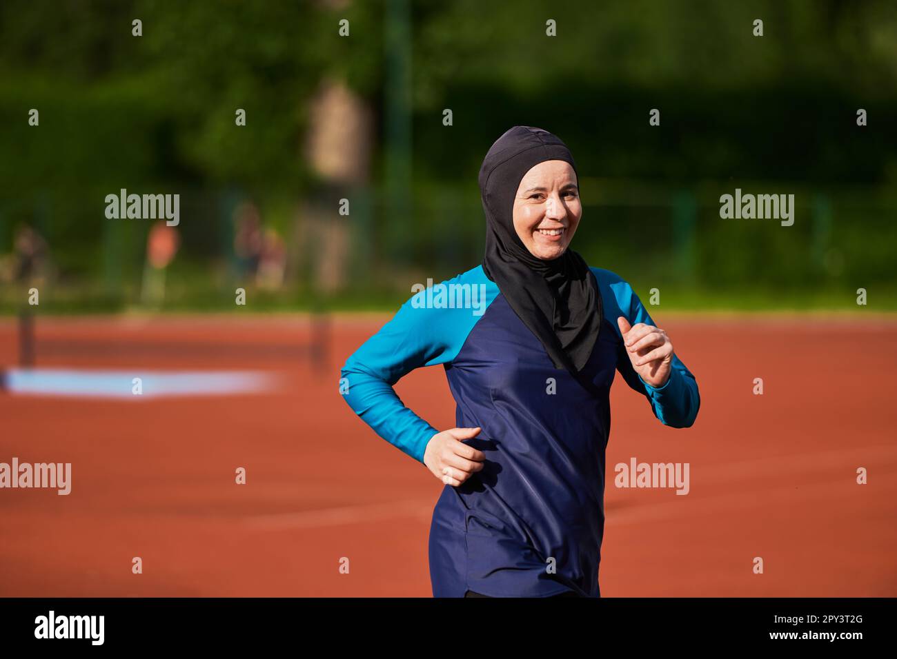 A muslim woman in a burqa sports muslim clothes running on a marathon ...
