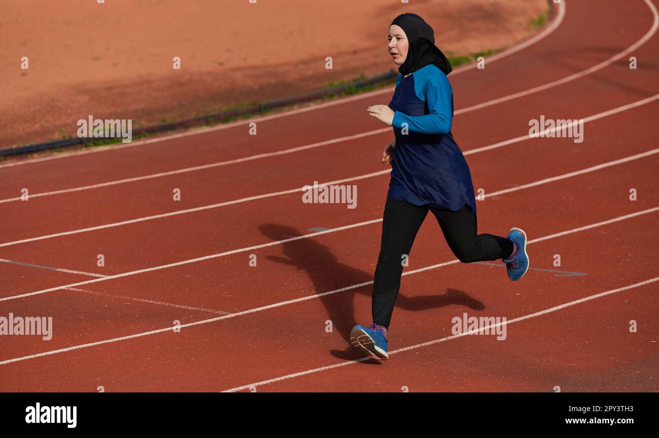 A muslim woman in a burqa sports muslim clothes running on a marathon ...
