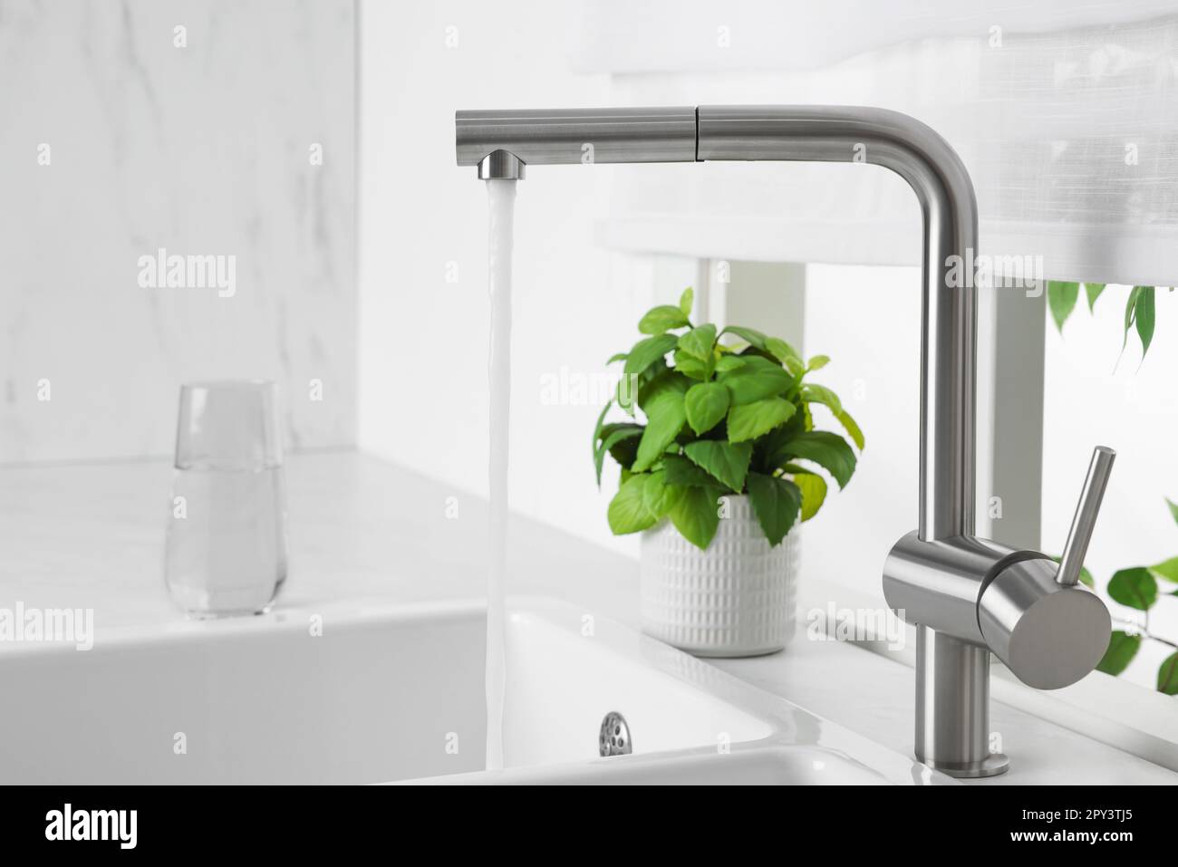 Stream of water flowing from tap in kitchen Stock Photo - Alamy