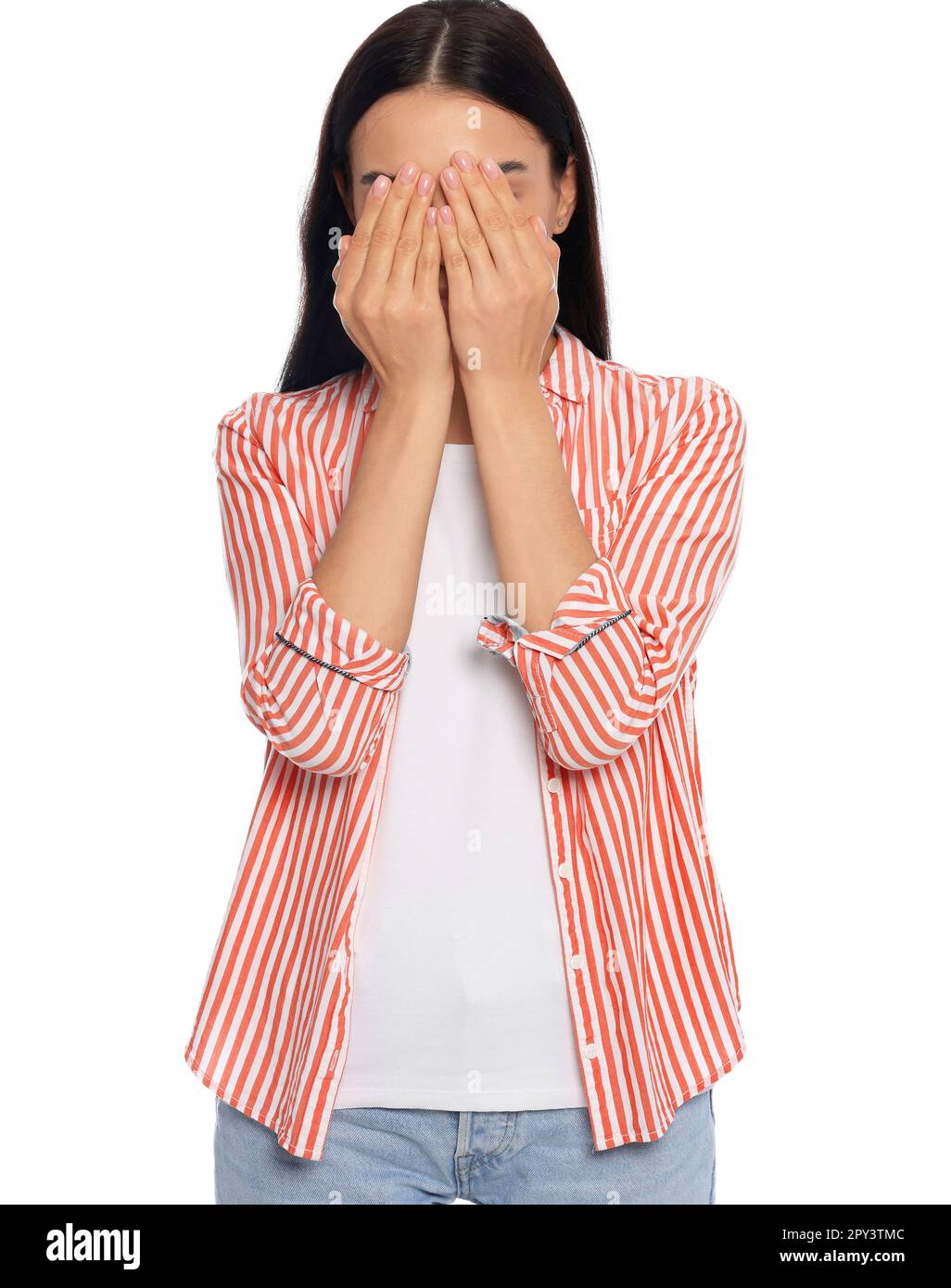 Embarrassed young woman covering face with hands on white background ...