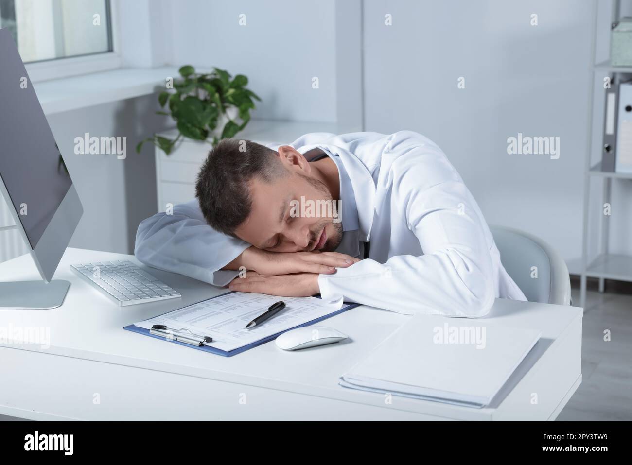 Exhausted doctor sleeping at workplace in hospital Stock Photo - Alamy