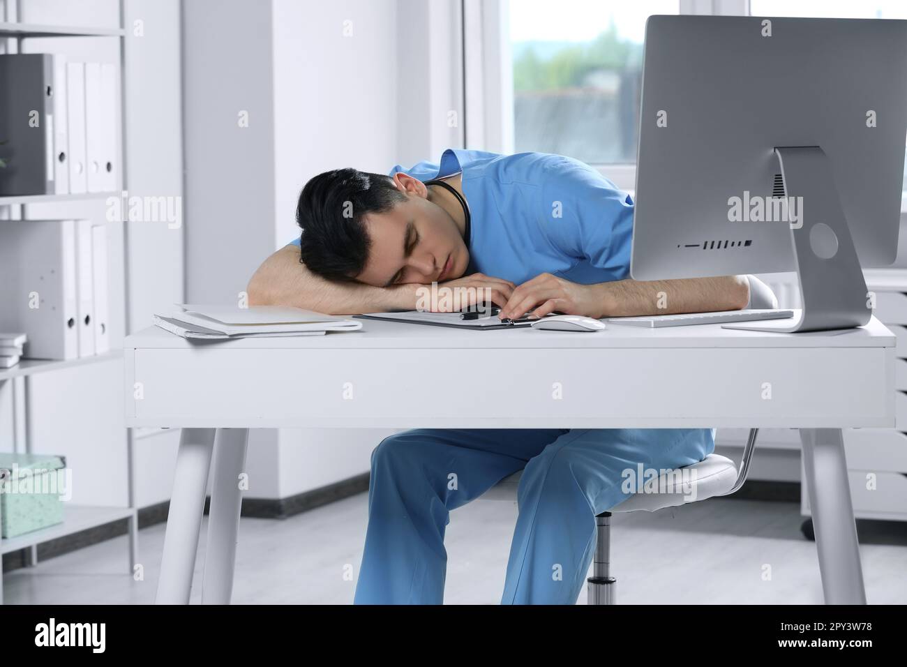 Exhausted doctor sleeping at workplace in hospital Stock Photo - Alamy