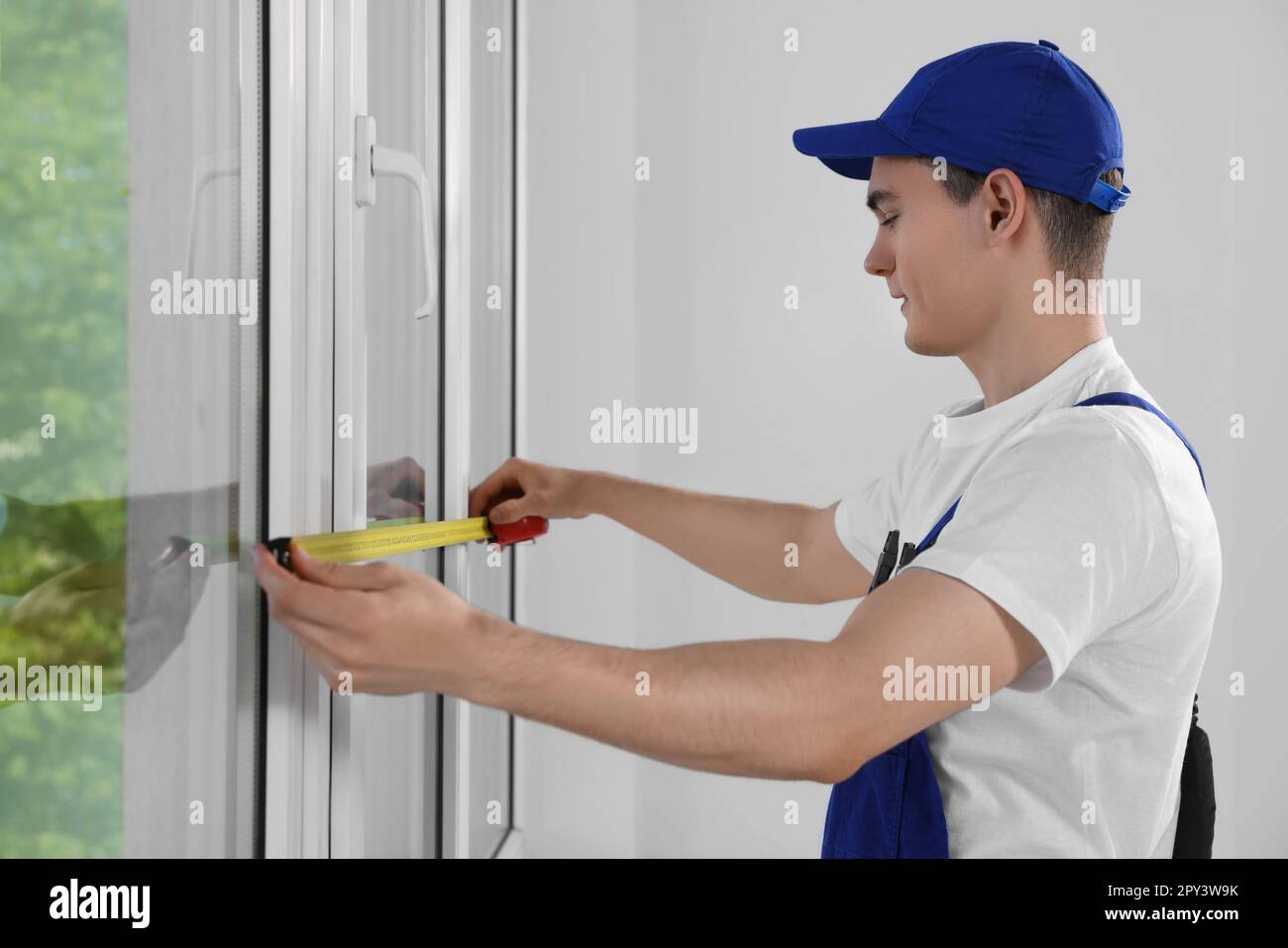 Worker measuring plastic window indoors. Installation process Stock ...